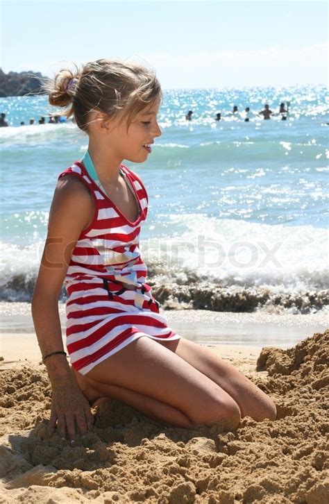 Eine lächelnde junge Mädchen auf dem Sand am Meer Stockfoto Colourbox