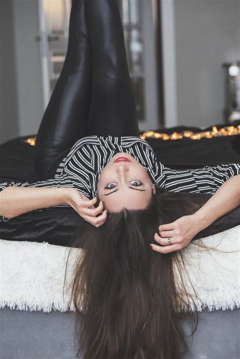 La Ragazza Con Un Appassionato Considera Il Letto Immagine Stock