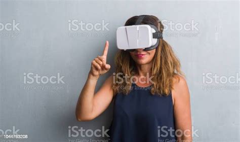 중세 스페인 여자 회색 그런 지 서 가상 현실 안경을 착용 아이디어 놀된 벽 또는 행복 한 얼굴 넘버 원 가리키는 손가락 질문 3차원 형태에 대한 스톡 사진 및 기타 이미지