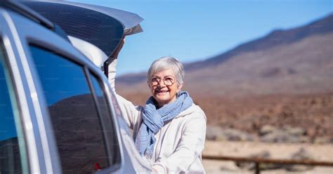 자동차의 자동차 오프닝 후드를 가진 야외 산악 여행에서 웃고 있는 성숙한 노인 여성 사진 Unsplash의 수송 이미지