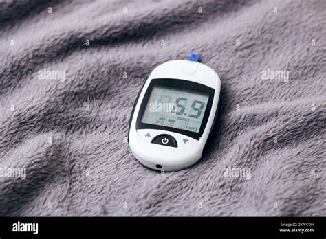 A Glucose Meter Provides A Reading Alongside An Insulin Injection Pen All Displayed Over A Soft