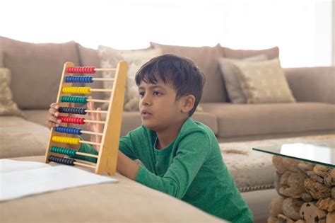 Premium Photo Boy Learning Mathematics With Abacus In A Comfortable Home