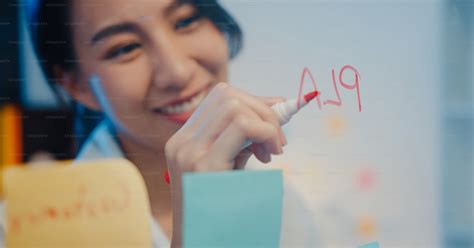 아시아 사업가들은 투명한 유리 벽 뒤에 서서 진행 상황을 가리키는 관리자의 말을 듣고 회의를 브레인스토밍하고 작업자는 벽에 스티커 메모를 게시합니다 사업 영감 사업