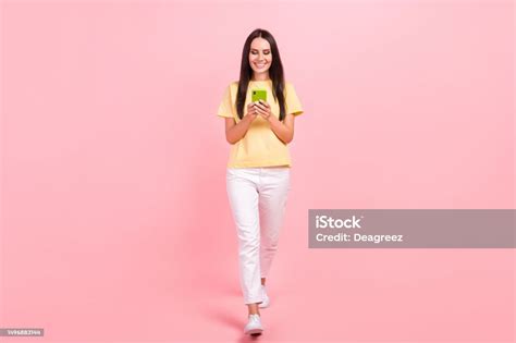 반짝이는 귀여운 여자가 노란색 티셔츠를 입고 걷는 채팅 아이폰 현대 장치 격리 된 핑크 색상 배경의 전체 길이 사진 30 34세에 대한 스톡 사진 및 기타 이미지 Istock