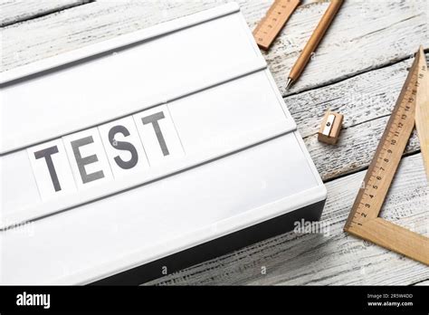 Board With Word Test And School Stationery On White Wooden Background