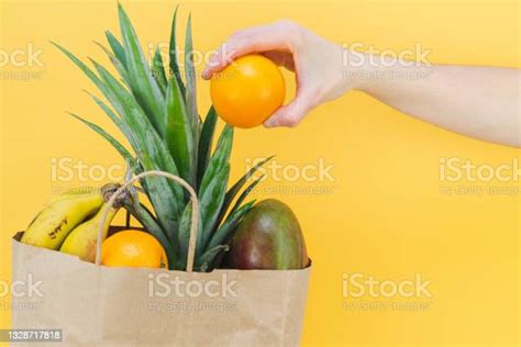노란 배경에 여성의 손으로 열대 과일로 가득 종이 쇼핑 가방 공간을 복사합니다 슈퍼마켓에 대한 스톡 사진 및 기타 이미지 슈퍼마켓 주황색 가방 Istock