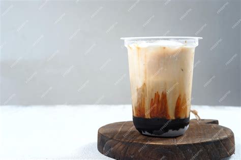 Premium Photo Iced Coffee In A Plastic Cup On White And Grey Background