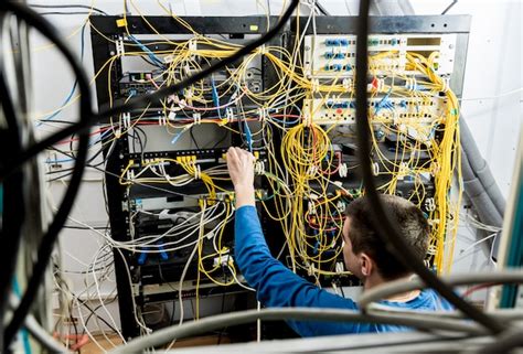 Premium Photo Network Engineer Working In Server Room Connecting Network Cables To Switches