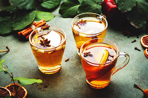 뜨거운 멀드 사이다 유리 컵 향신료가 든 사과 배 및 오렌지 사이다 잎이 있는 녹색 테이블에 발효된 저알코올 겨울 칵테일 음료 상위 뷰 열 개념에 대한 스톡 사진 및 기타