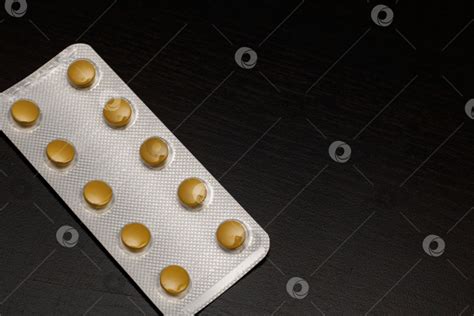 Блистер с желтыми таблетками на белом фоне Ozero российский фотосток