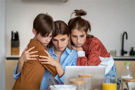 Adolescentes Niños Apoyan a La Madre En La Cocina Mirando La Pantalla Del Portátil Con Malas