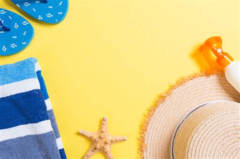플립 플롭 밀짚 모자 불가사리 자외선 차단병 노란색 배경 상단보기에 바디 로션 스프레이 플랫 레이 여름 해변 바다 액세서리 배경