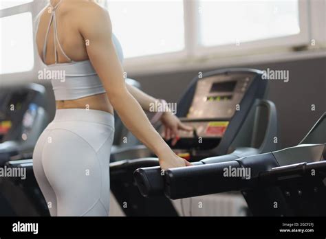 Athletic Girl Turns On Treadmill For Training Closeup Stock Photo Alamy