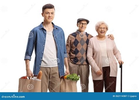 Joven Ayudando A Una Pareja Mayor Con Bolsas De Comestibles Imagen De