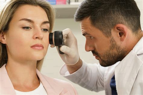 Doctor And Client Woman In Dermatology Clinic Dermatologist Is Using