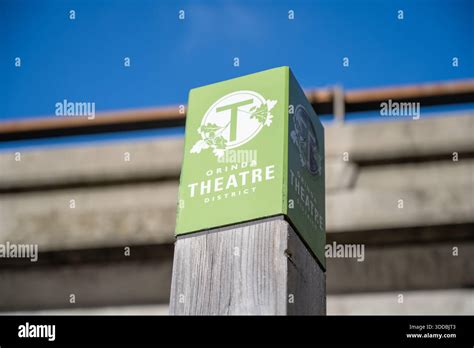 Orinda Theatre District Sign On Wooden Post With Overpass And Clear