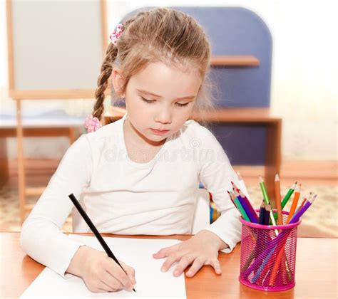 Милая маленькая девочка пишет на столе Стоковое Фото изображение насчитывающей людск одно