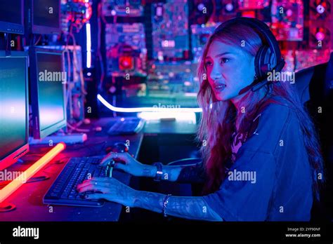 woman hacker sitting in front of a computer typing on keyboard hacking