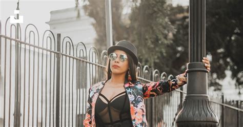 검은 바지와 검은 색과 빨간색 꽃 긴 소매 셔츠를 입은 여자 갈색 모래 위에 서 사진 Unsplash의 무료 사람의 이미지