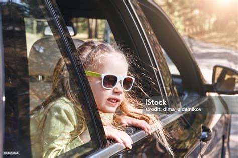 귀여운 쾌활 한 작은 백인 소녀는 차 안에 앉아 창 밖으로 찾고 미소 가족도로 여행 금발 머리에 대한 스톡 사진 및 기타 이미지
