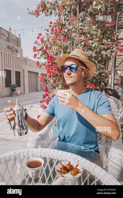 As He Sits In A Traditional Cafe In The Uae Man Sips On Fragrant Arab