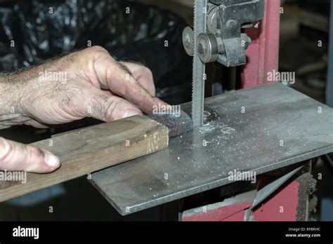 The Metal Worker Carefully Shapes A Metal Piece Using A Band Saw For Cutting A Bokeh Background
