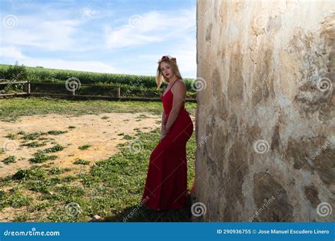 блондинка с длинными волосами молодая и красивая одетая в длинное красное платье и корону