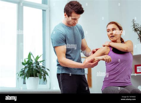 Shoulder Massage Serious Male Masseur Looking At His Patients Shoulder