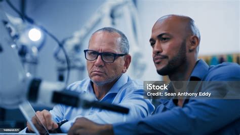 자동화 로봇 및 기계에 대한 검사 분석 및 엔지니어링 설계를 위한 실험실의 남성 미래형 창고 팀워크 및 남성 엔지니어는 공장에서