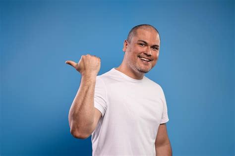 Premium Photo Man Smiling And Pointing Back With Thumb