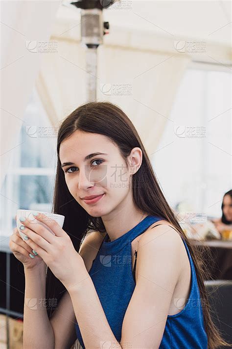 一个非常漂亮的女商人坐在咖啡馆里手里拿着一杯咖啡