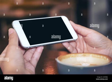 mockup image of hands holding and using a white mobile phone with blank