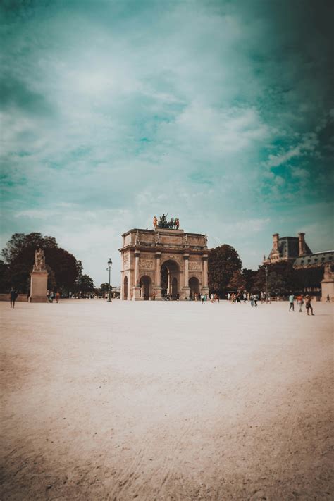 낮 동안 푸른 하늘 아래 갈색 콘크리트 건물 근처의 하얀 모래 위를 걷는 사람들 사진 Unsplash의 무료 파리 이미지