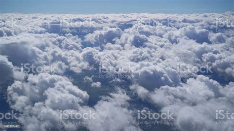 맑고 화창한 날 푸른 하늘에 도시 위의 하얀 솜털 구름에 비행기 창문에서 볼 수 있습니다 비행기 비즈니스 항공편으로 휴가 여행 공중 뷰에 대한 스톡 사진 및 기타 이미지