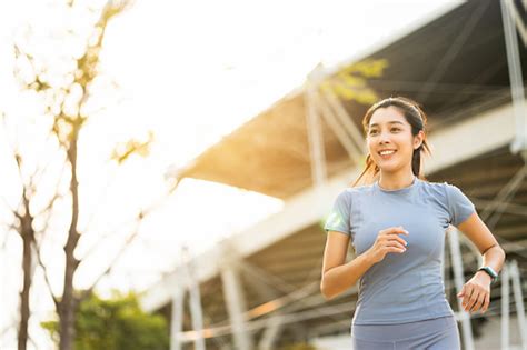 스포츠 경기장에서 달리는 스포츠웨어를 입은 매력적인 아름다운 여성 야외에서 조깅하는 여자에 적합합니다 아침에 운동 운동 건강하고