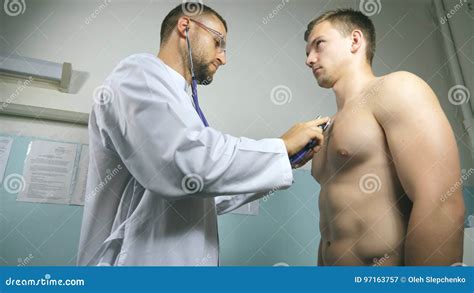 Doctor Examining Young Male Patient With Stethoscope Medical Worker