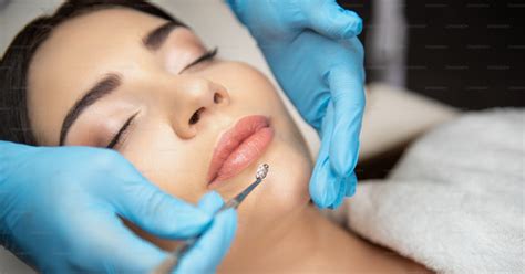 미용사가 특별한 도구로 얼굴에서 불순물을 제거하는 동안 데이베드에 누워 있는 젊은 여성 사진 Unsplash의 청소 이미지