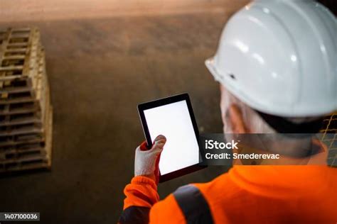안전 유니폼과 하드 모자를 착용 공장 노동자의 상단보기 태블릿 컴퓨터를 사용하여 생산 공정을 제어 안전모에 대한 스톡 사진 및