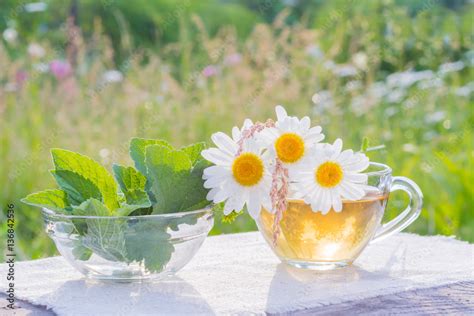 Травяной чай на столе на фоне луга Stock Photo | Adobe Stock