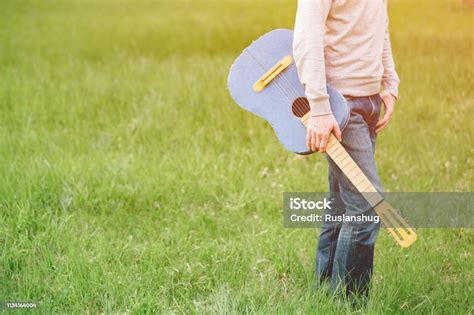 남자 스웨터와 청바지를 들고 빈티지 사용자 정의 기타는 Copyspace와 녹색 잔디에 서 Classical Concert에 대한 스톡 사진 및 기타 이미지