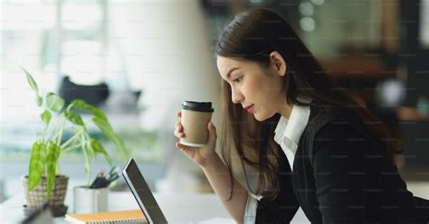 종이컵을 들고 현대적인 사무실에서 디지털 태블릿으로 작업하는 사업가의 측면 모습 사진 Unsplash의 사업 이미지