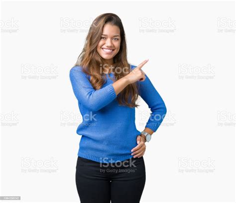 격리에 파란색 스웨터를 입고 젊은 아름 다운 갈색 머리 여자 측면 표시 광고 심각 하 고 진정 얼굴에 손으로 손가락으로 패 니 얼을 배경 가리키기에 대한 스톡 사진 및 기타