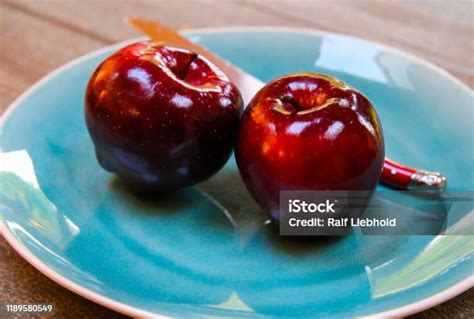 칼로 파란색 중국 접시에 고립 된 두 개의 빨간 점선 반짝 이별 디저트 사과의 닫습니다 건강한 식생활에 대한 스톡 사진 및 기타 이미지 건강한 식생활 과일 독일