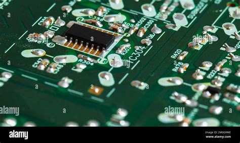 micro chip and capacitors mounted on a green printed circuit board
