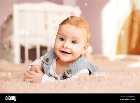 Newborn 5 Months Old Lies On Bed On Stomach Baby Girl Smiles And Plays