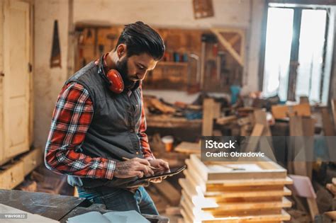 태블릿을 사용 하 여 그의 워크샵 Pn 가구 프로젝트에서 작업 하는 목수 Diy에 대한 스톡 사진 및 기타 이미지 Diy 계획 공예 Istock