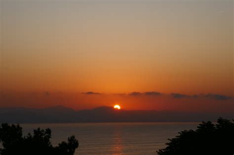 코르푸 섬의 산 바로 위에 솟아있는 오렌지 태양과 함께 일출 0명에 대한 스톡 사진 및 기타 이미지 0명 그리스 그리스