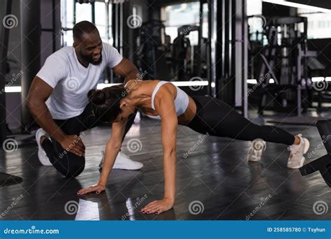 Fitness Instructor Exercising With His Client At The Gym Stock Photo Image Of Equipment