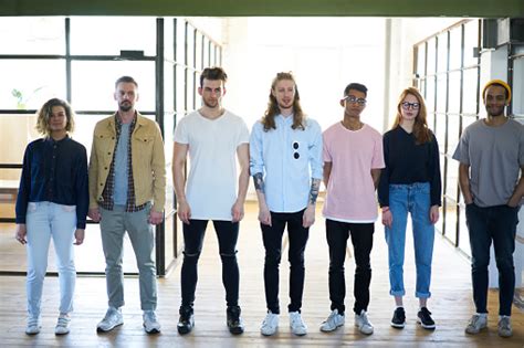 젊은 남성 및 여성 팀 멤버 현대 로프트 인테리어 사무실 비즈니스 개발자 컨퍼런스 회의에 포즈의 자신감 번영 승무원 캐주얼 유행 옷 서 함께 입은 사무실에 대한 스톡 사진