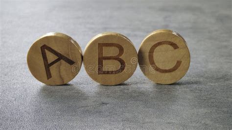 wooden alphabet blocks a b and c on a gray surface stock image